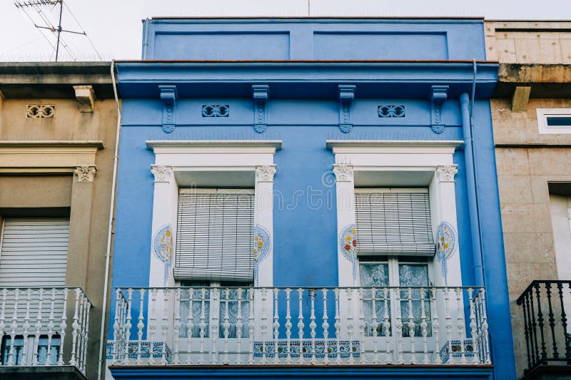 Classic Blue Facade with Ornamental Details and Wrought Iron Balcony ...