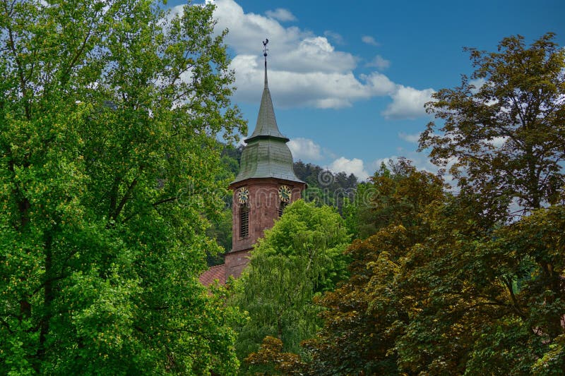 Classic Clock Tower Situated Against a Clear Blue Sky with Lush Green ...
