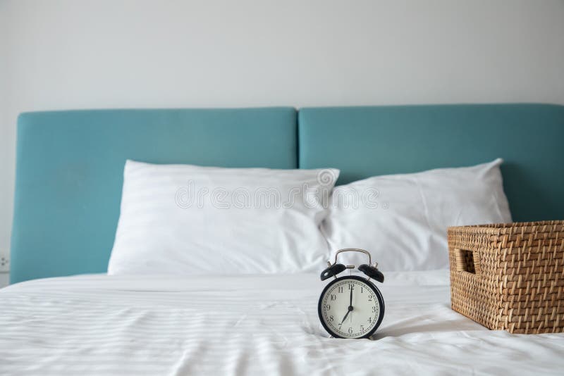 Classic Clock on White Bed with Wooden Basket on Bed in Bedroom Stock ...