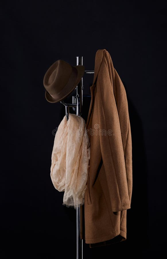 Hat and Coat Hanging on Coat Rack on Black Stock Photo - Image of ...