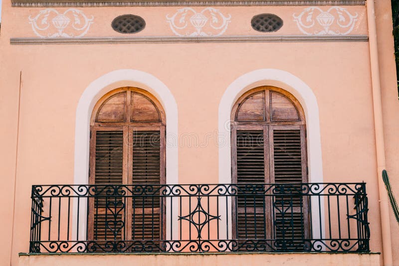 Classic European Pink Facade with Wrought Iron Balcony and Arched ...