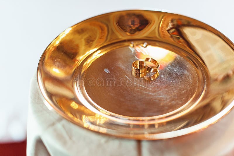 Classic Gold Wedding Ring on a Gold Plate Stock Image - Image of plate ...