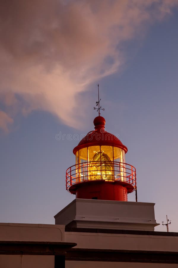 The Classic Illuminated Lighthouse with a Lamp on during the Sunset ...