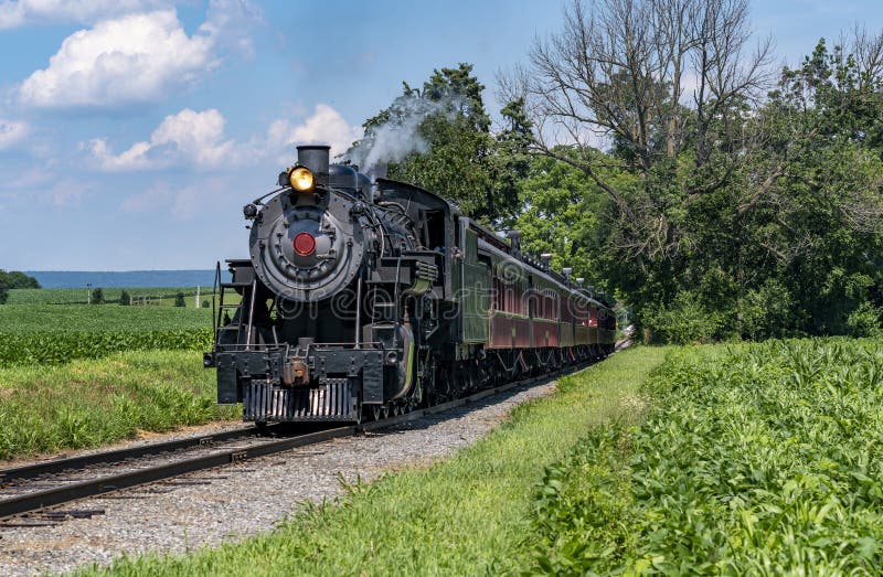 Vintage Steam Train Travels through Lush Green Fields on a Sunny Day ...