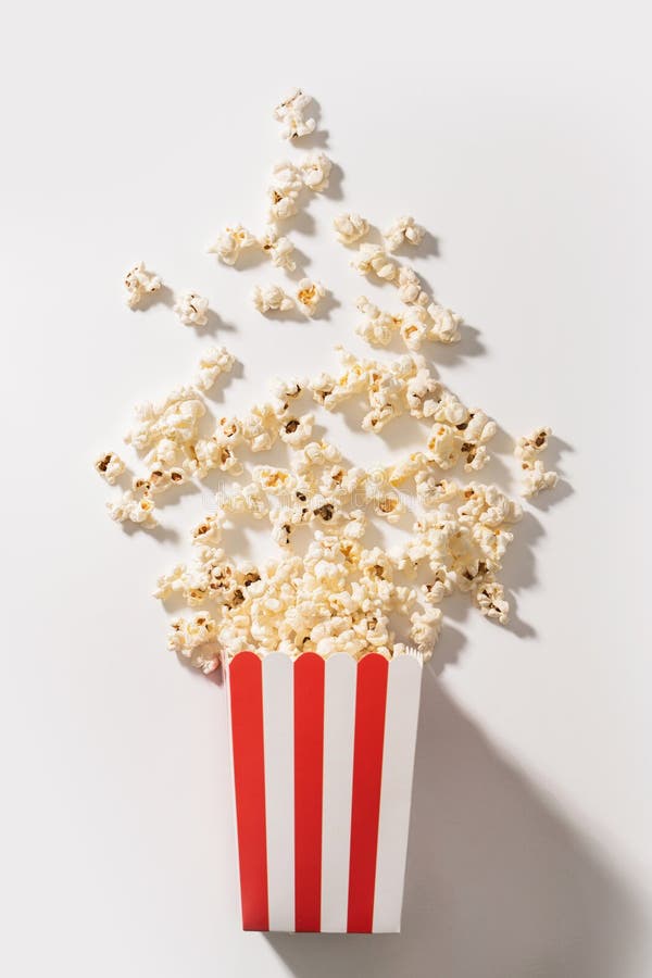 Classic Striped Popcorn Box with Scattered Kernels on a Textured Dark ...