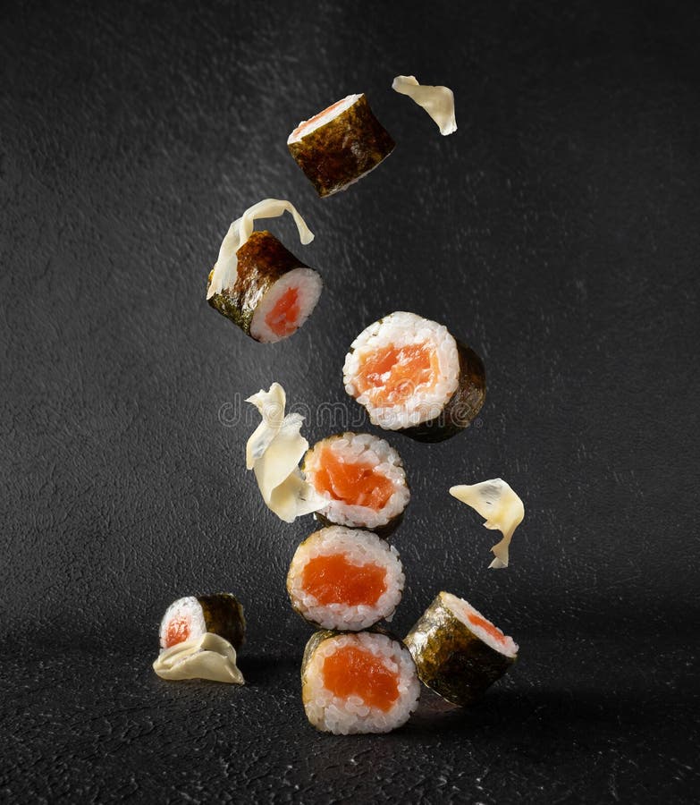 Classic Sushi Rolls with Ginger Falling Down on Black Background Stock ...