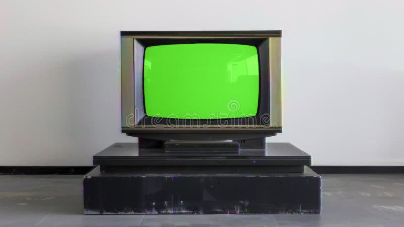 Classic Television with a Green Screen on a Black Stand Against a Plain ...