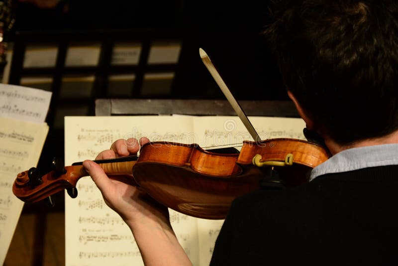 Classical Musician Playing the Violin and Reading Music Notes Stock ...