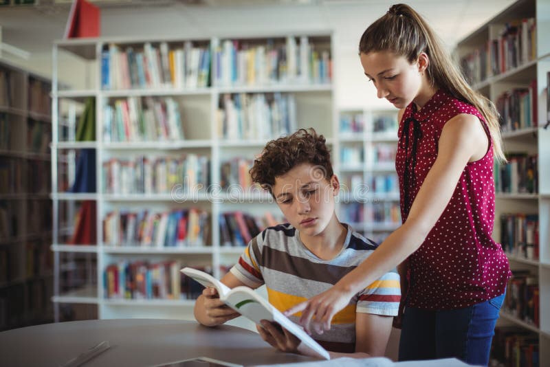 Classmates Reading Book in Library Stock Photo - Image of information ...