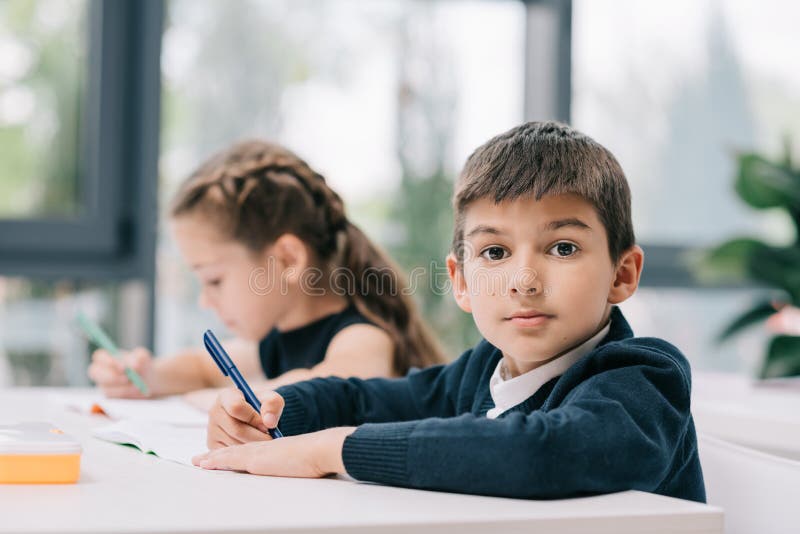 Classmates Sitting at Desk and Writing in Exercise Books Stock Image ...
