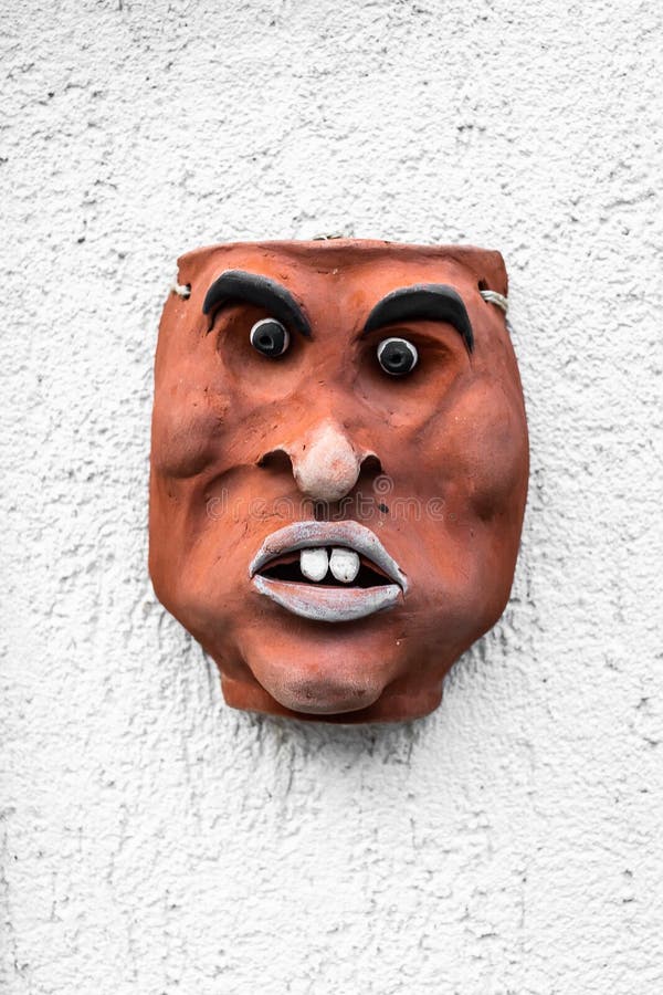 Clay Mask of a Funny Face with Two Teeth Hanging on a Wall Stock Photo ...