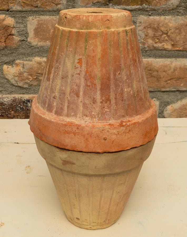 Used Terracotta Pots Stacked Upside Down on a White Table with Brick ...