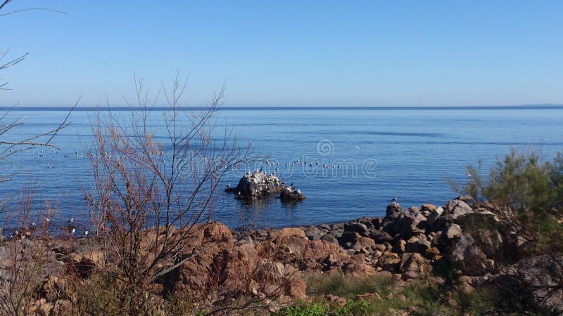 Blue Ocean Water. Some Rocks and Clean Blue Sky Stock Image - Image of ...