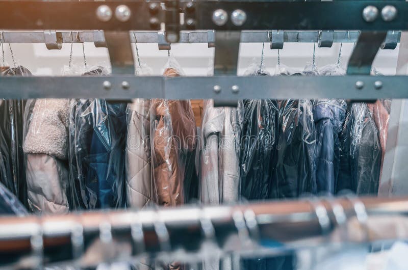 Clean Clothes on Hangers in the Dry Cleaners. Conveyor with Hangers of ...