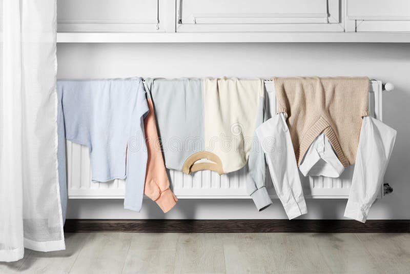Clean Clothes Hanging on White Radiator in Room Stock Photo - Image of ...