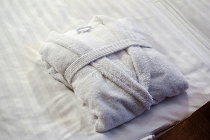 Folded Bathrobe on Bed in Room. White Robe Stock Photo - Image of ...