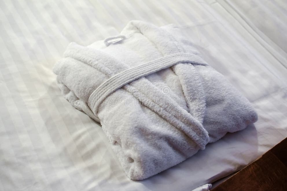 Clean Folded Bathrobe on White Bed. Stock Photo - Image of folded ...