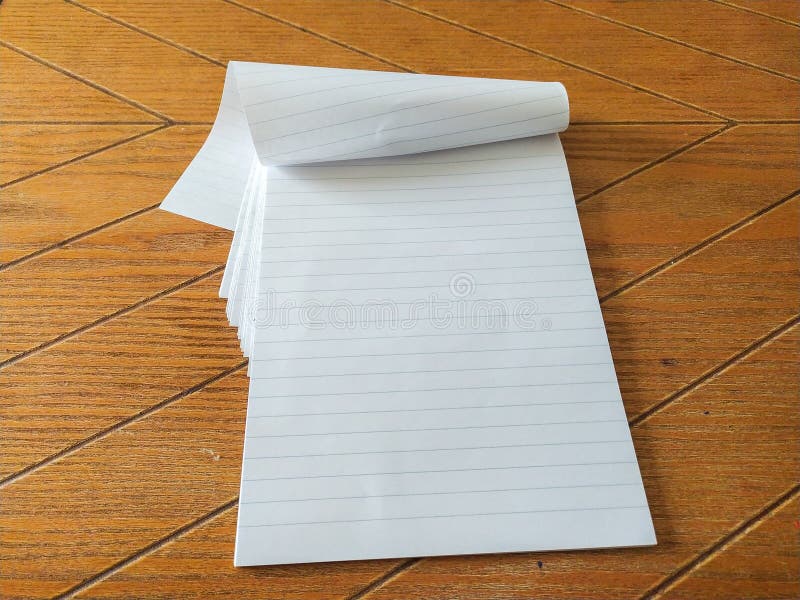 A Clean, Lined Notepad Rests Open on a Rich Wood Grain Surface. the ...
