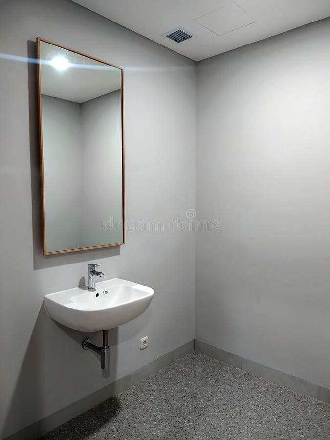 A Clean and Minimalistic Restroom with a Wall-mounted Sink and a Large ...