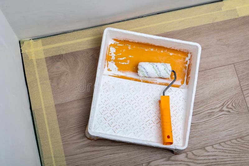 Clean Paint Roller and an Empty Paint Tub on the Floor Stock Photo ...