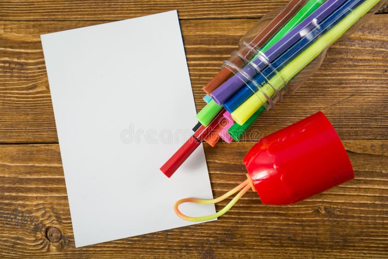On the Table are Markers, Paper Clips and a Notebook with the ...