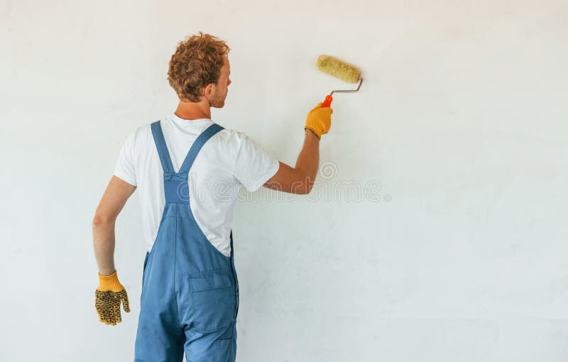 Clean Walls. Young Man Working in Uniform at Construction at Daytime ...