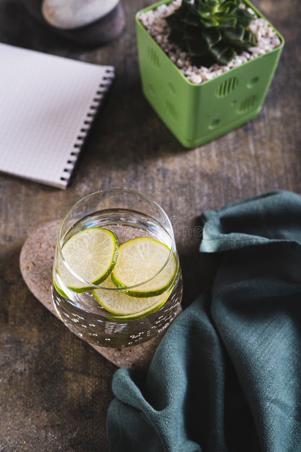 Clean Water with Lime Slices in a Glass on a Stone, Notepad and ...