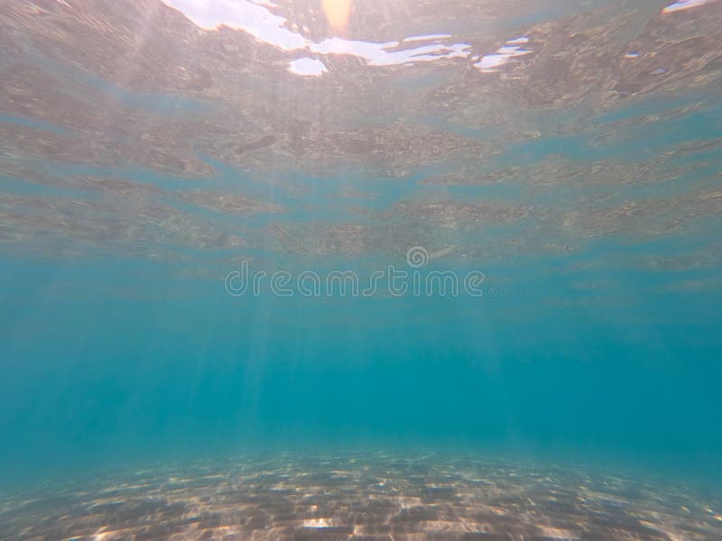 Clean Water. Under the Water, the Rays of the Sun and the Sandy Bottom ...