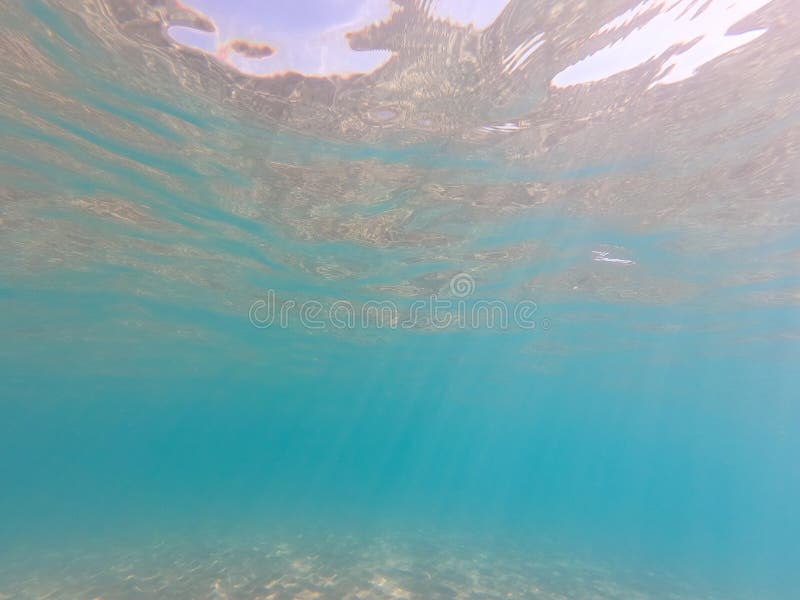 Clean Water. Under the Water, the Rays of the Sun and the Sandy Bottom ...