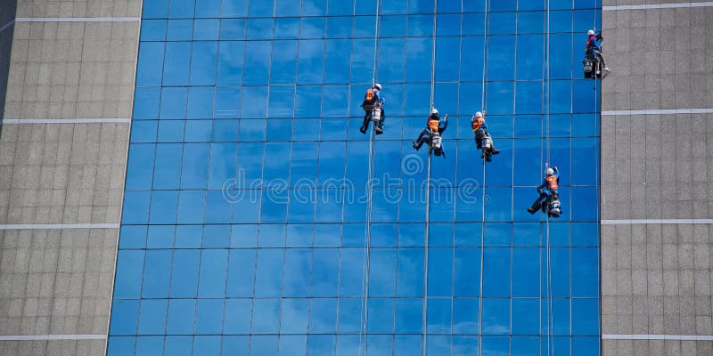 Window Cleaner Cleaning Window with Squeegee and Wiper on a Sunny Day ...