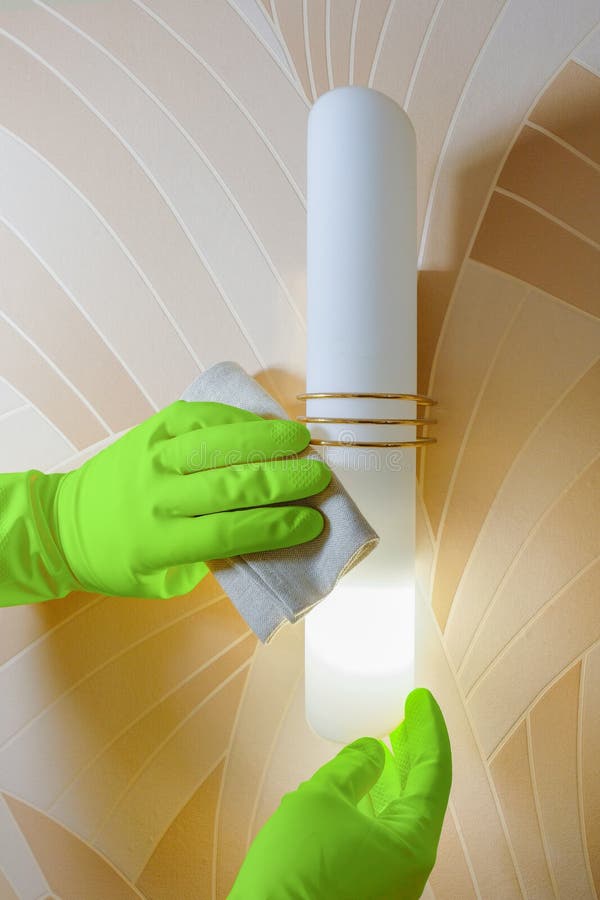The Cleaner Wipes the Dust from the Lamp. House Cleaning Stock Image ...