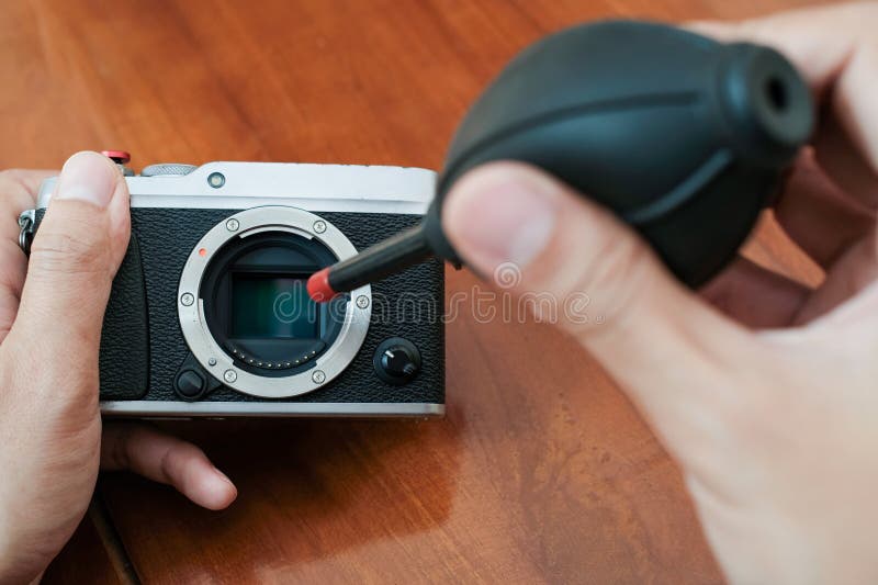 Cleaning the Camera Sensor with a Blower on Wooden Table and. Cleaning ...