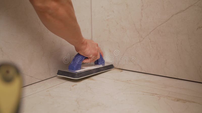 The Master Cleans the Joints between the Tiles in the Bathroom ...