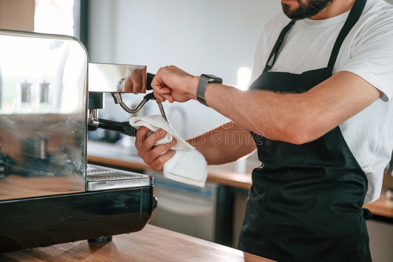 Cleaning Coffee Machine. Cafe Worker in White Shirt and Black Apron is ...