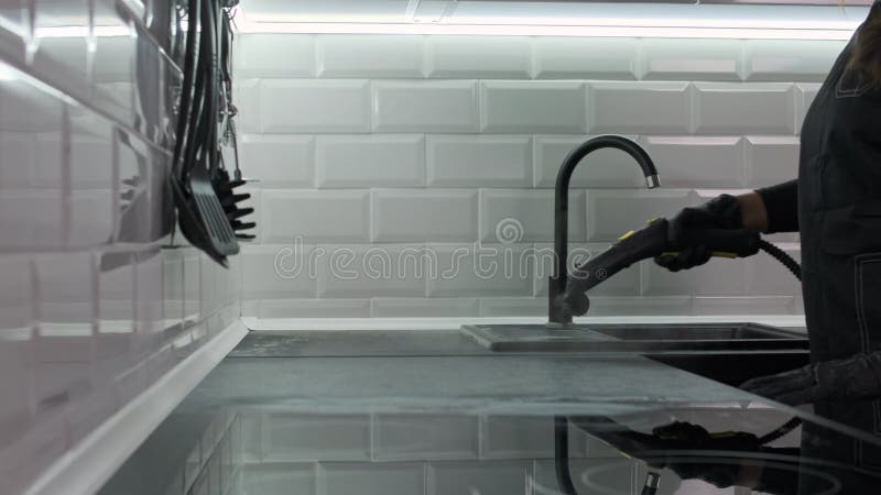 Cleaning Kitchen Sink with Steam Cleaner in a Spotless Kitchen Stock ...