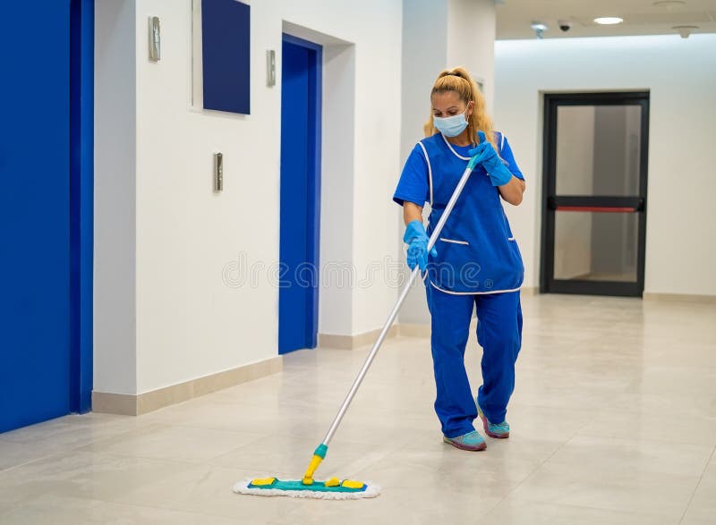 A Cleaning Lady with a Mask on Her Face Cleans the Hallway Stock Image ...