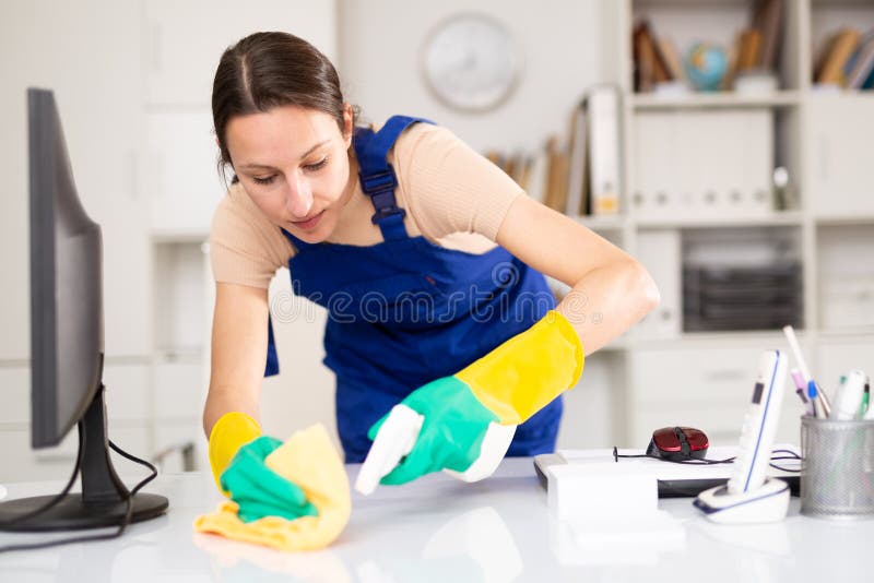 Cleaning Lady in Overalls Wipes Dust from Table in Office Stock Photo ...
