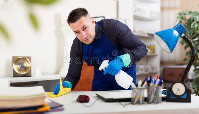 Cleaning Man in Overalls Wipes Dust from Table in Office Stock Image ...