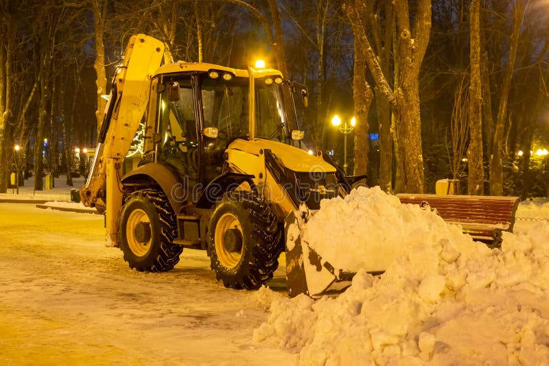 Cleaning Snow in the Park in Winter with a Tractor in the Evening Stock ...