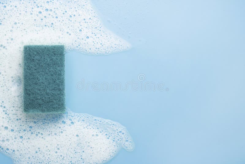 A Cleaning Sponge in White Foam, Mousse, on a Blue Background. Frame ...
