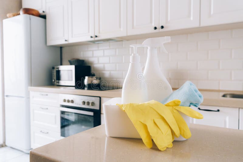 Cleaning Supplies on Kitchen Counter with Gloves and Spray Bottles ...