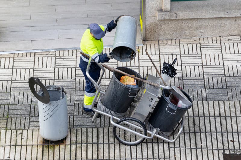 Cleaning Worker Emptying the Trash into His Cleaning Cart on a City ...