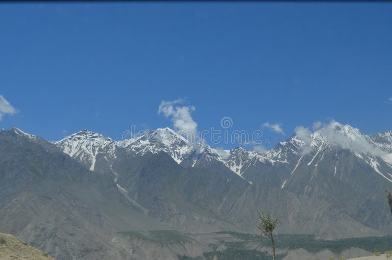Clear Blue Sky and a Mountain with Its Peaks Covered with Snow Stock ...