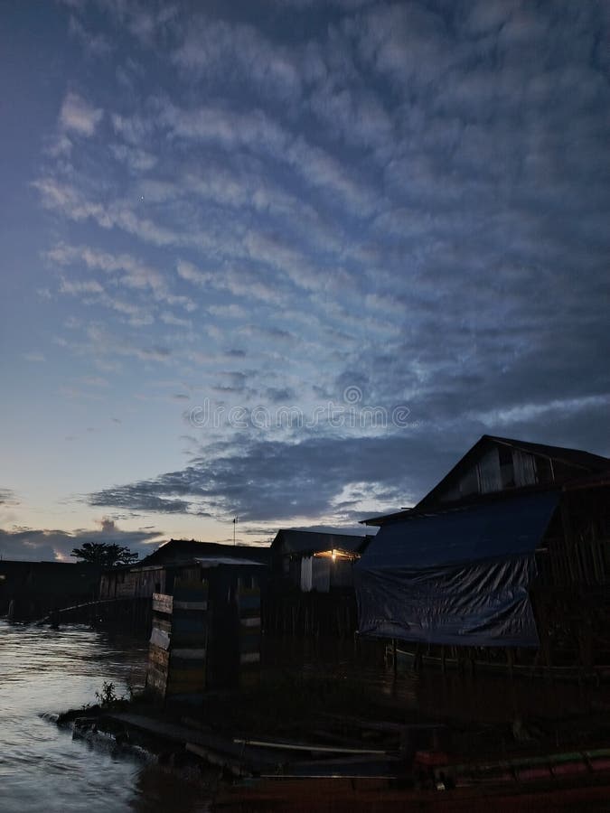 Clear Blue Sky with Soft Clouds Drifting Gently Above Rustic Houses and ...