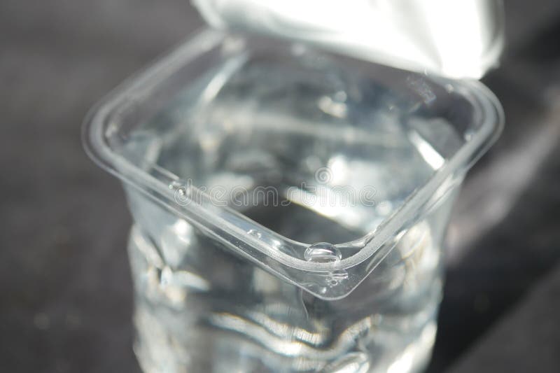 Clear Container Filled with Water on a Dark Surface in Daylight Stock ...