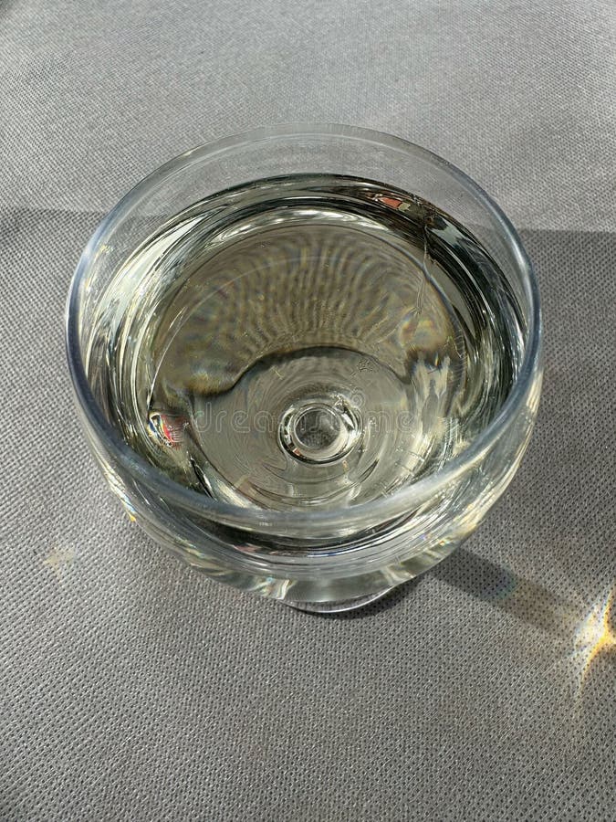 Clear Glass Bowl of Water on Textured Gray Surface with Light ...