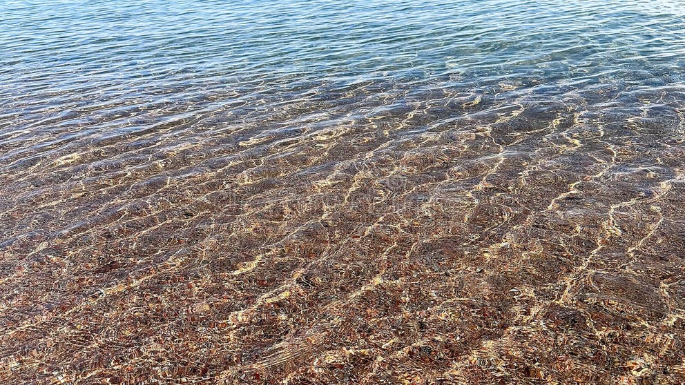 Clear Lake Water and Pebble Bottom Under Sun Reflections Stock Photo ...