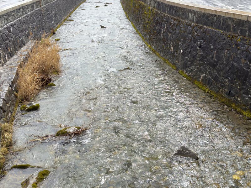 Clear Mountain Stream Flowing through Stone-walled Channel in Hermagor ...