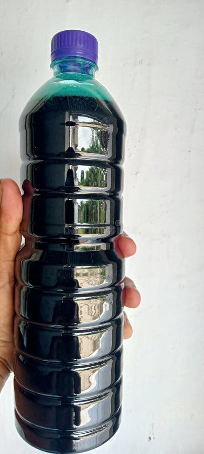 A Clear Plastic Bottle with a Blue Cap Containing a Dark Blue-black ...