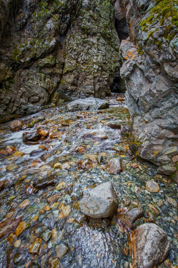 A Clear Stream Flows Rapidly through a Rugged Landscape, Surrounded by ...